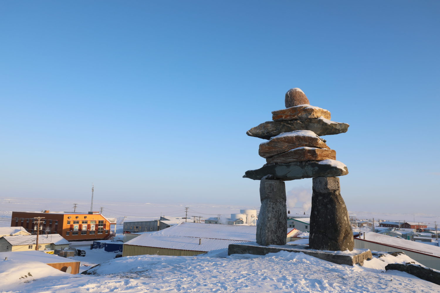 Single Inuksuk or Inukshuk landmark covered in snow on the top of the ...