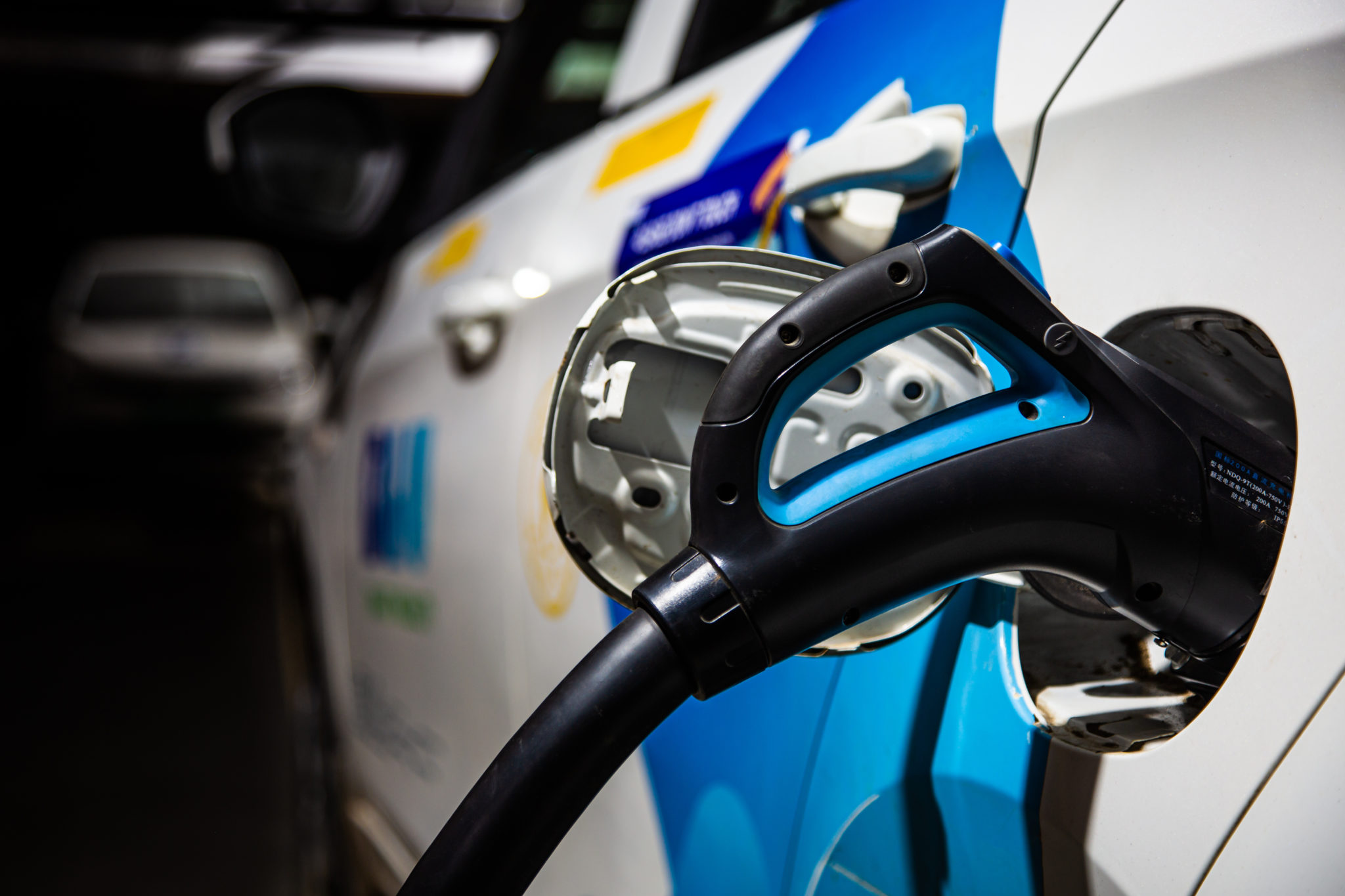 Electric vehicle car charging. Blue White electric car / vehicle ...