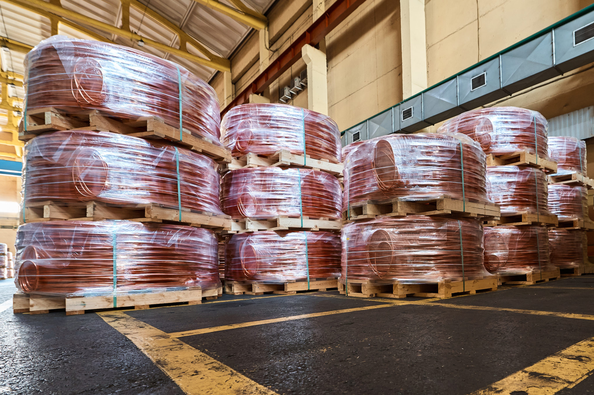 Rows of copper wire rod coils in production plant warehouse - MINING.COM