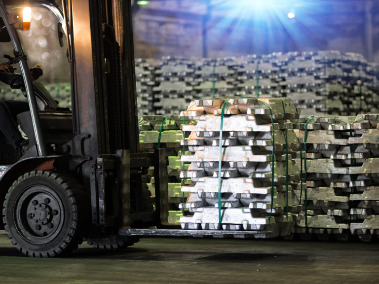 Stack of raw aluminum ingots in warehouse and handling by forklift ...